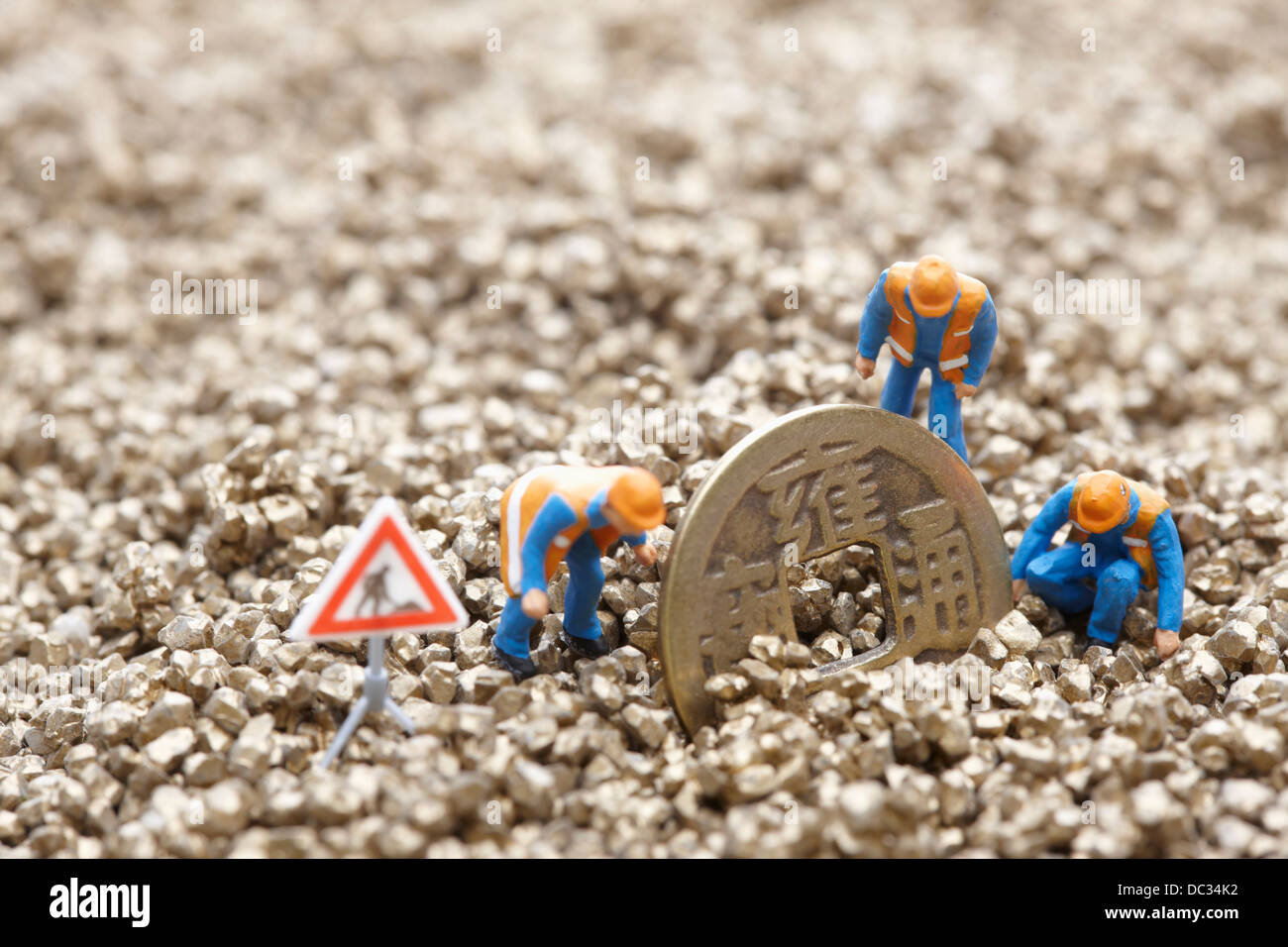 toy people digging Chinese golden coin Stock Photo - Alamy