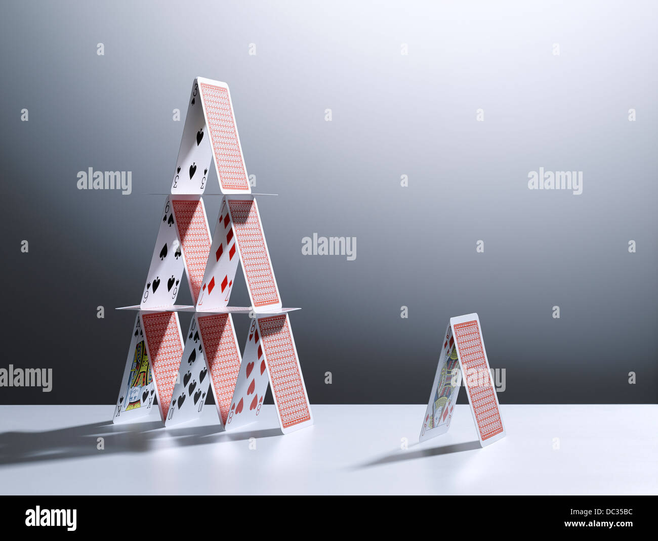 Small house of cards next to large house of cards Stock Photo - Alamy