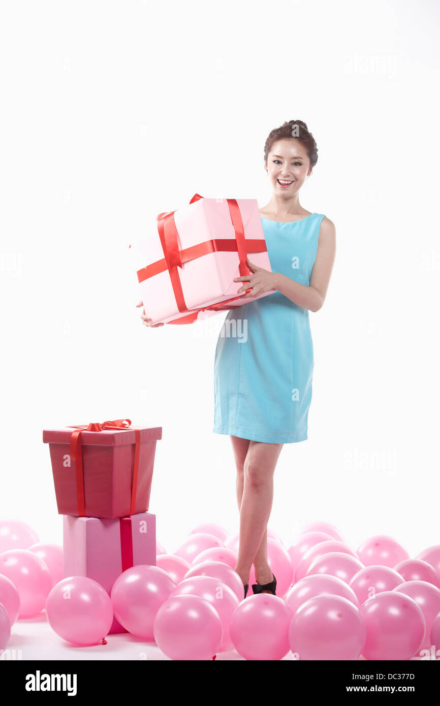 a lady in mini dress holding present boxes with pink balloons on the ...