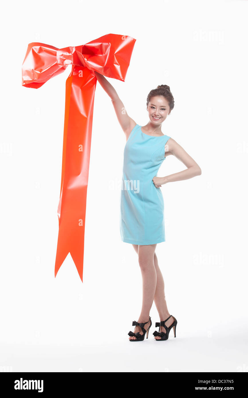 a lady in mini dress posing with big ribbon Stock Photo - Alamy