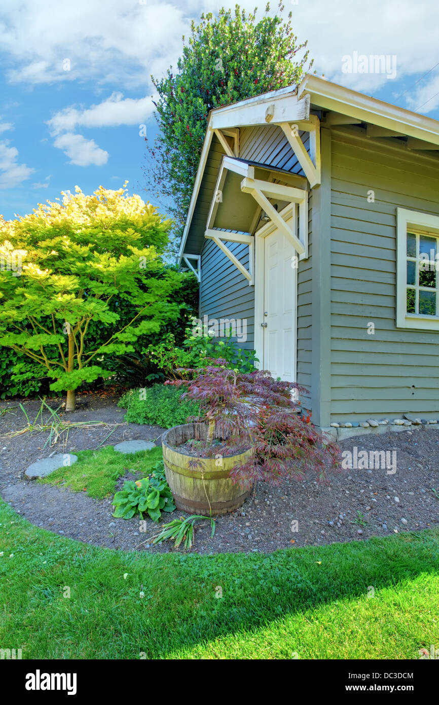 Grey small outdoor shed with backyard landscape Stock Photo - Alamy