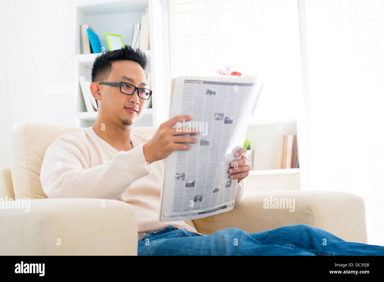 Southeast Asian male reading news paper Stock Photo - Alamy