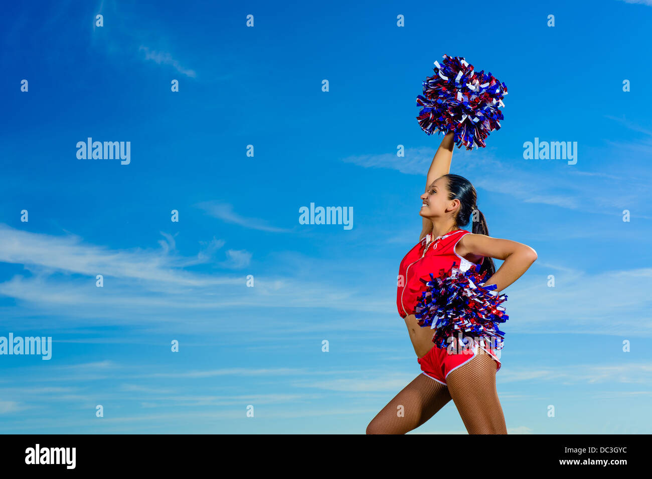 Young cheerleader in red costume with pampon Stock Photo - Alamy