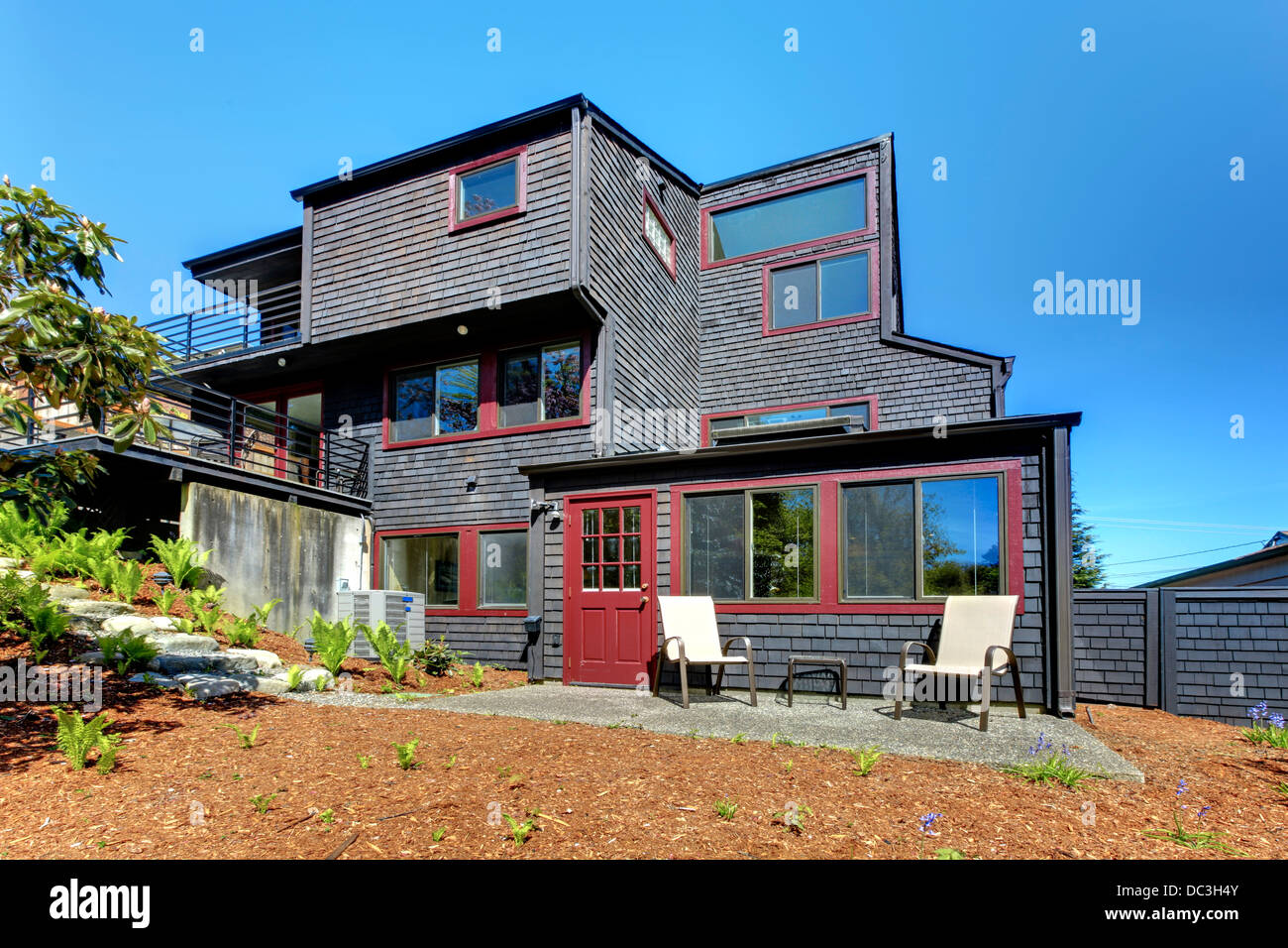 Black wooden modern house with spring backyard Stock Photo - Alamy