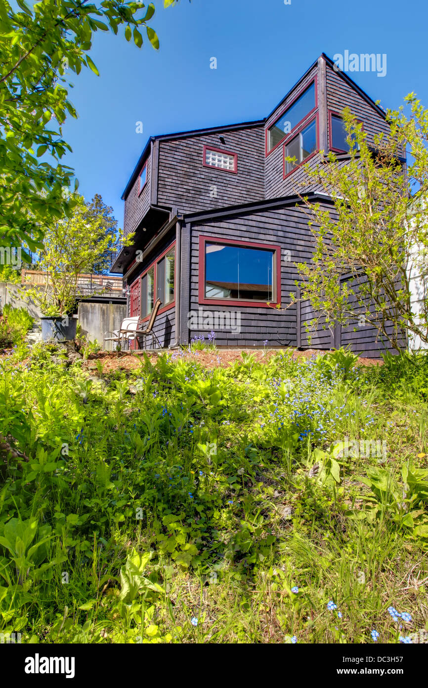 Black wooden modern house with spring backyard Stock Photo - Alamy
