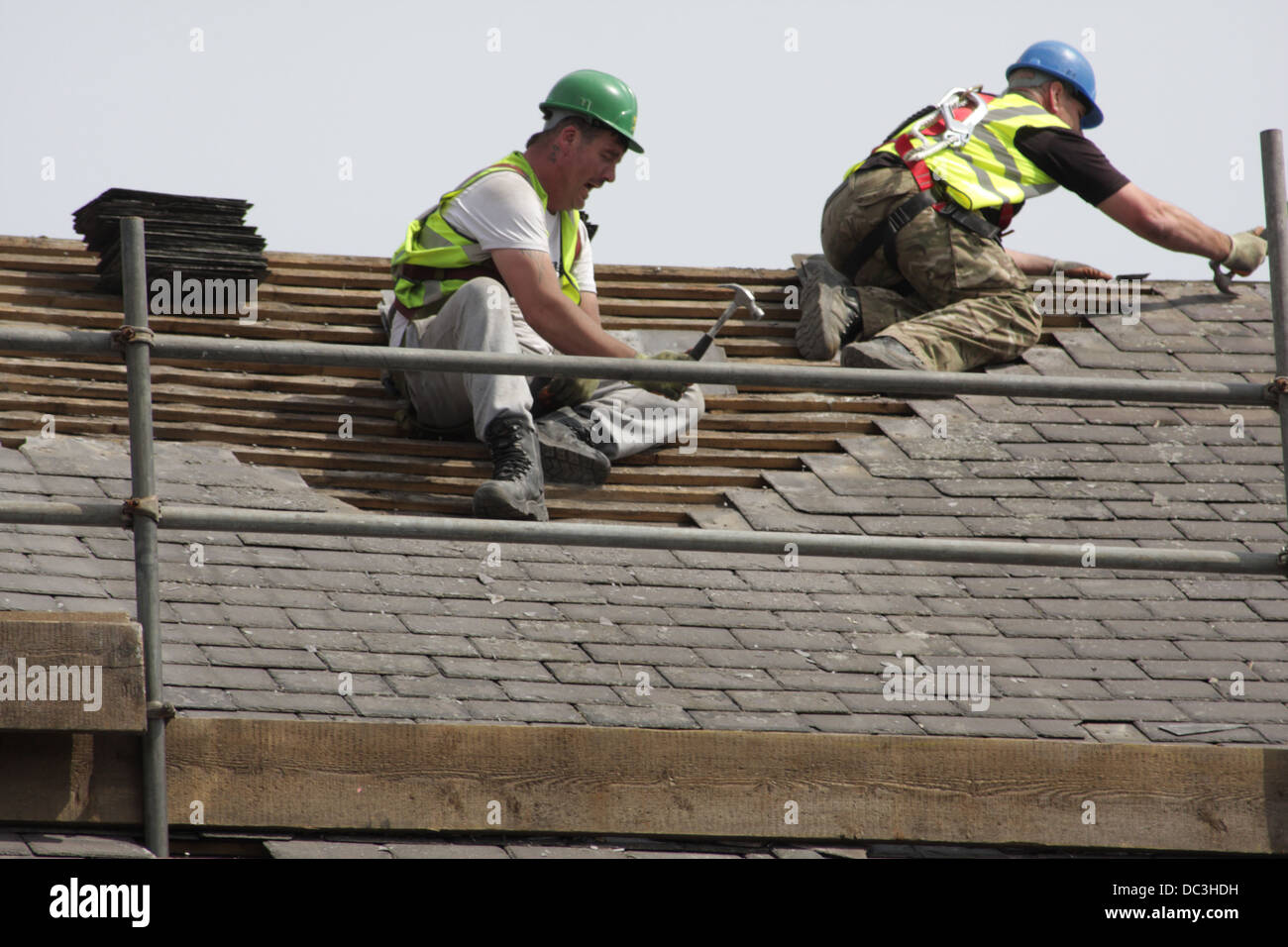 Workmen removing old roof tiles, prior to demolition of the properties ...