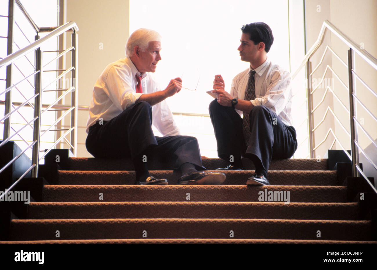 Experienced business man gives advice to young man Stock Photo - Alamy