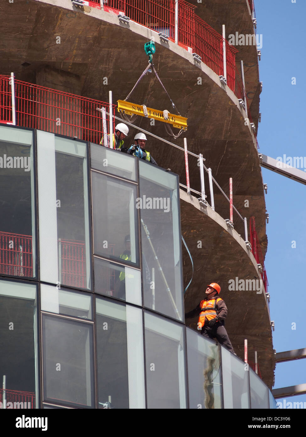 Construction workers installing windows on a building Stock Photo - Alamy