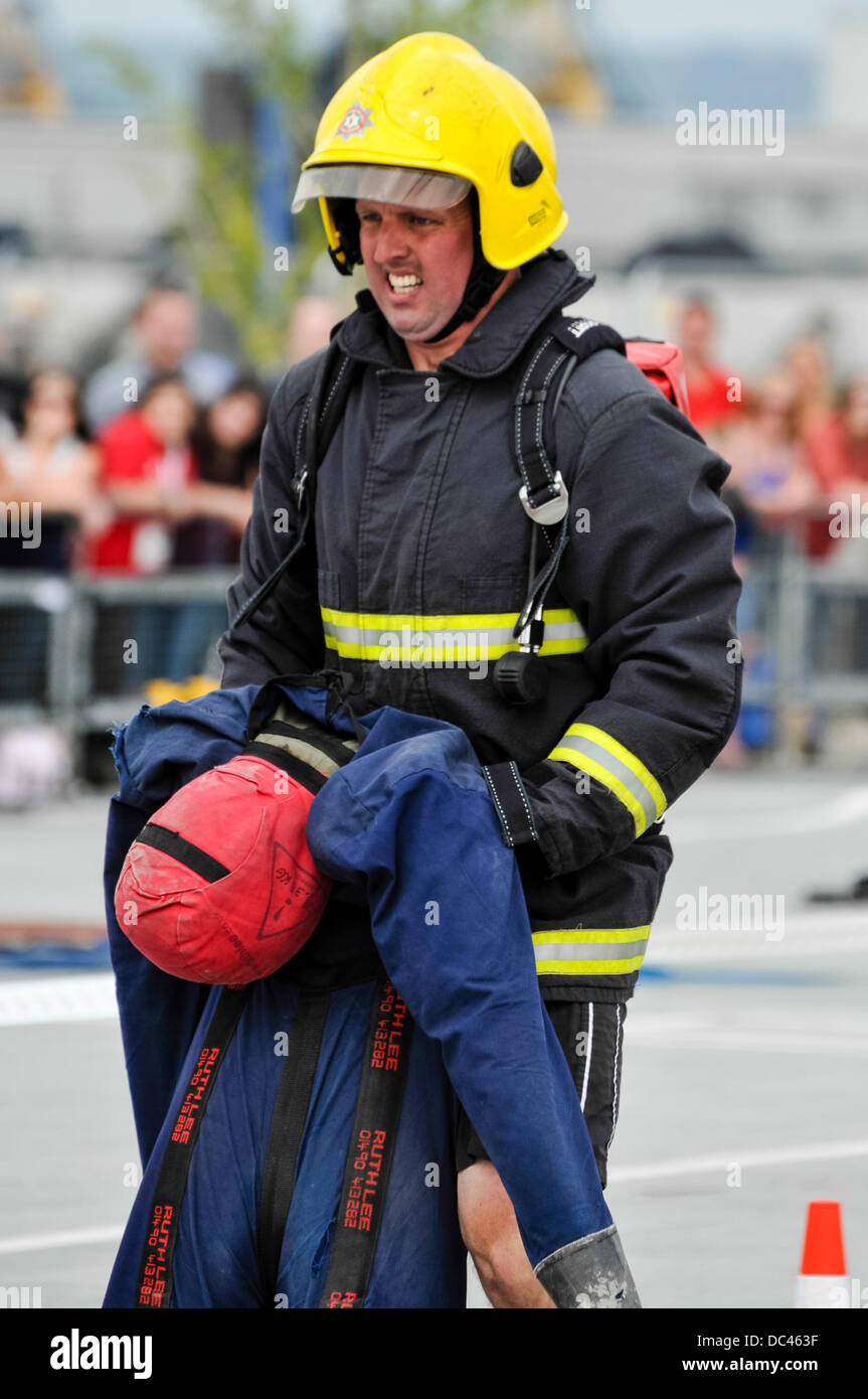 Belfast, Northern Ireland. 8th August 2013 - A fireman drags a heavy ...