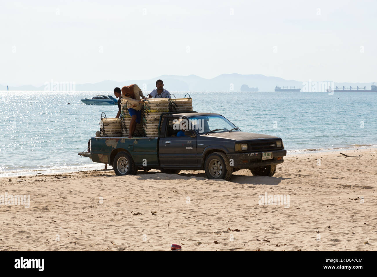 Thai Fishermen loading Fish onto a Pickup Truck on a secluded Beach in ...