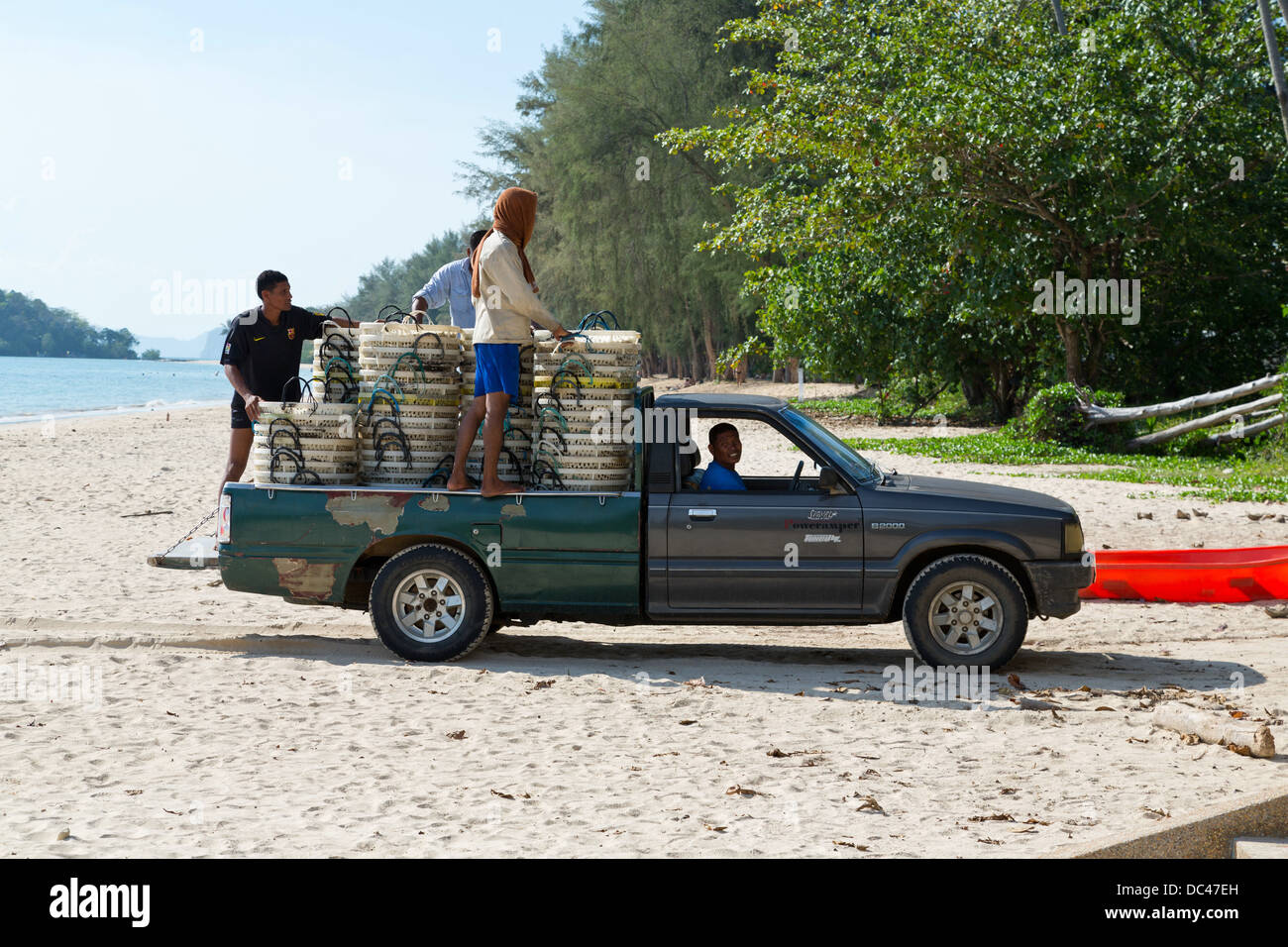 Thai Fishermen loading Fish onto a Pickup Truck on a secluded Beach in ...