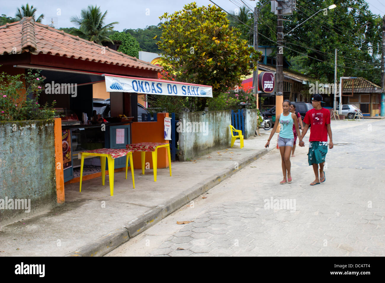 A young couple walking down a street in the coastal village of Barra do ...