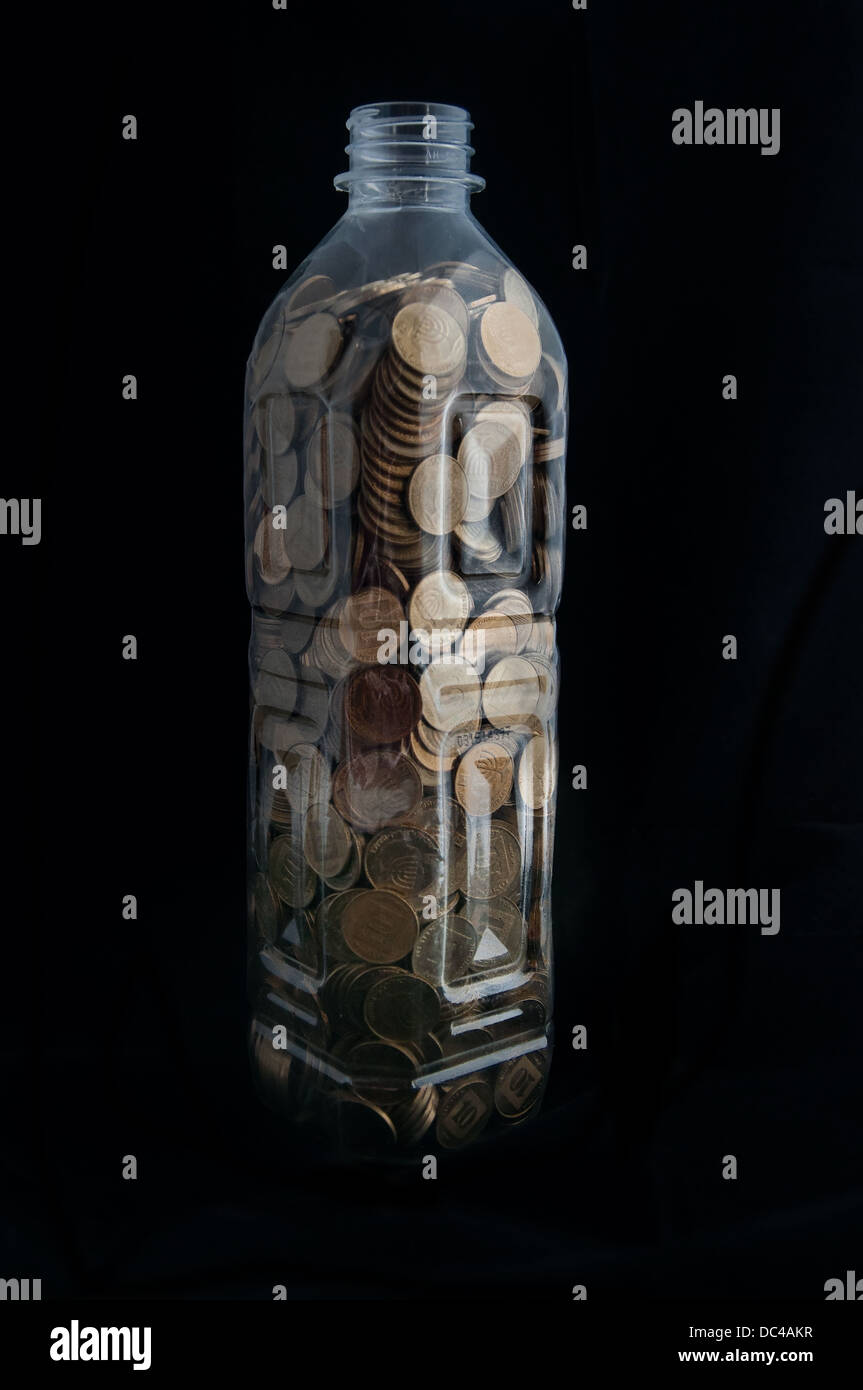 Plastic bottle with coins on black background Stock Photo - Alamy