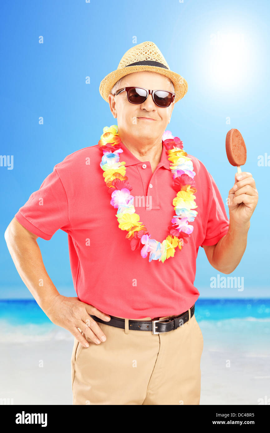Smiling gentleman with hat eating chocolate ice cream on a beach Stock ...