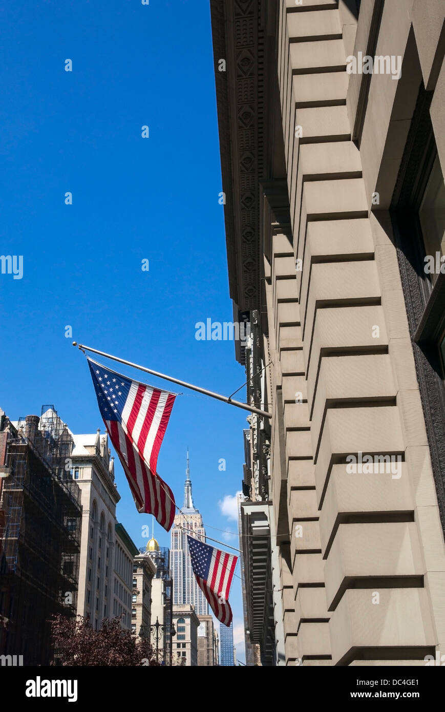 The Empire State Building with two American flags Stock Photo - Alamy