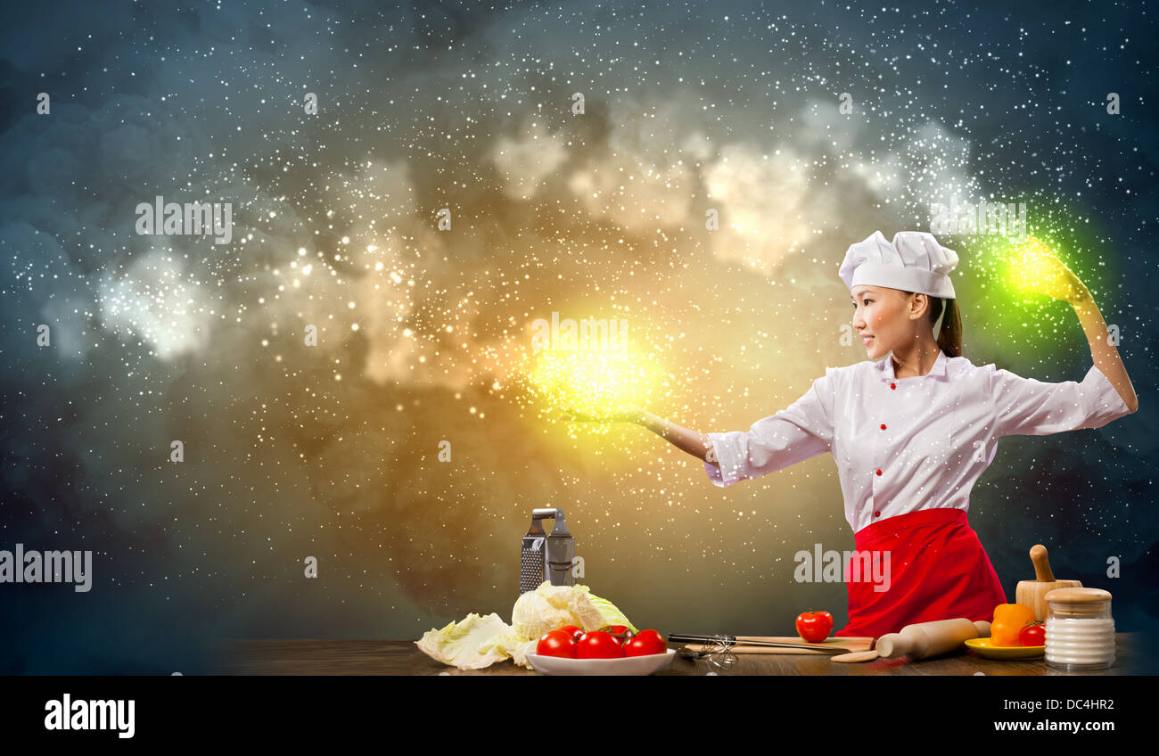 Asian female cooking with magic Stock Photo - Alamy