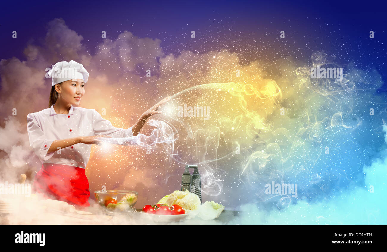 Asian female cooking with magic Stock Photo - Alamy