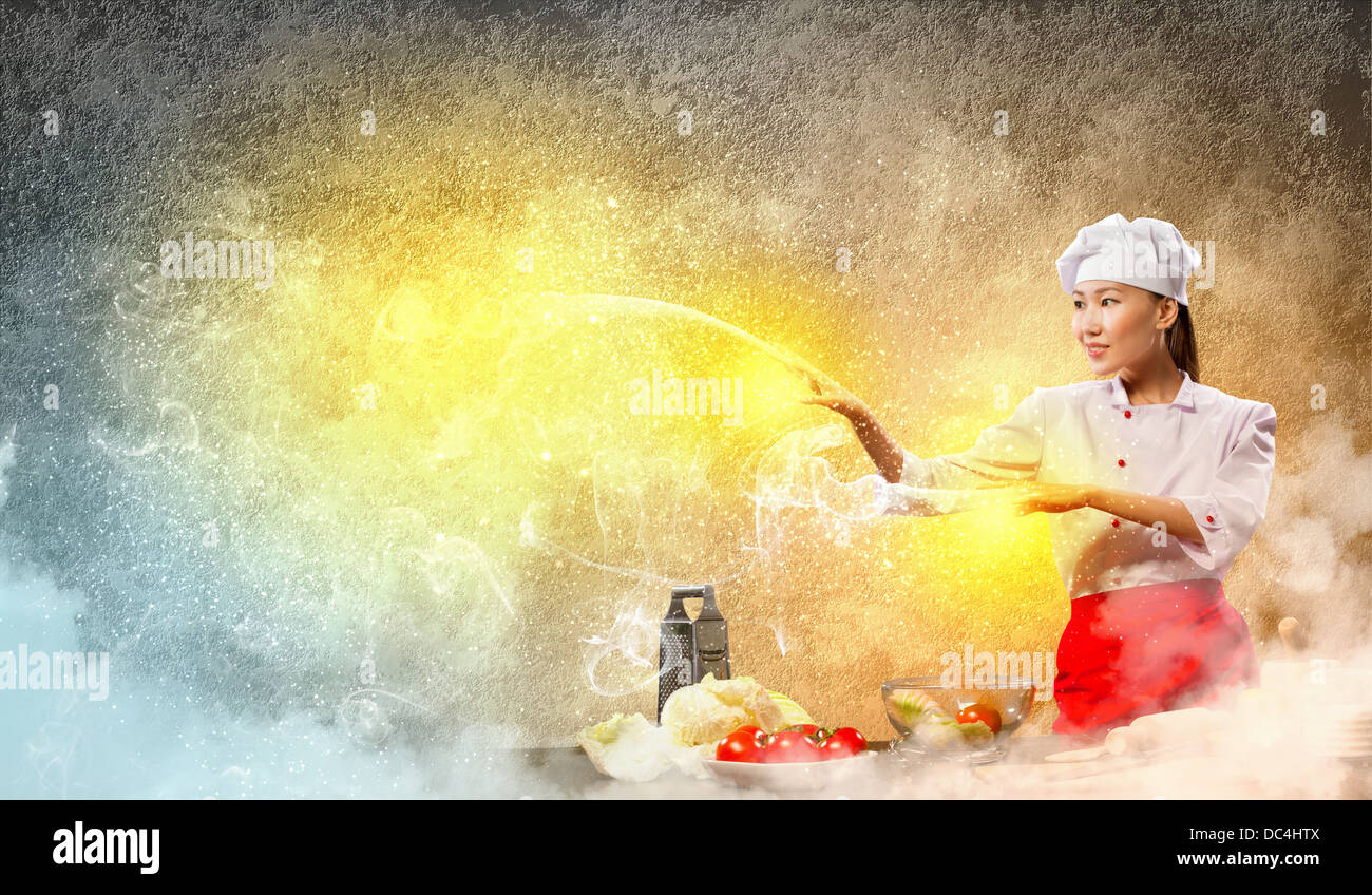 Asian female cooking with magic Stock Photo - Alamy
