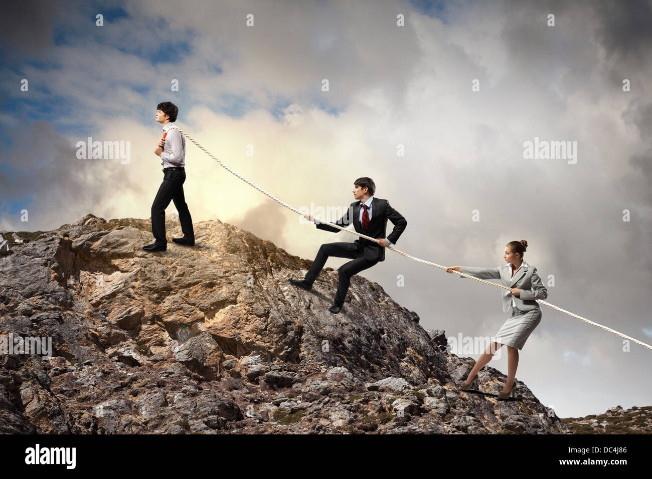 Three business people pulling rope Stock Photo - Alamy