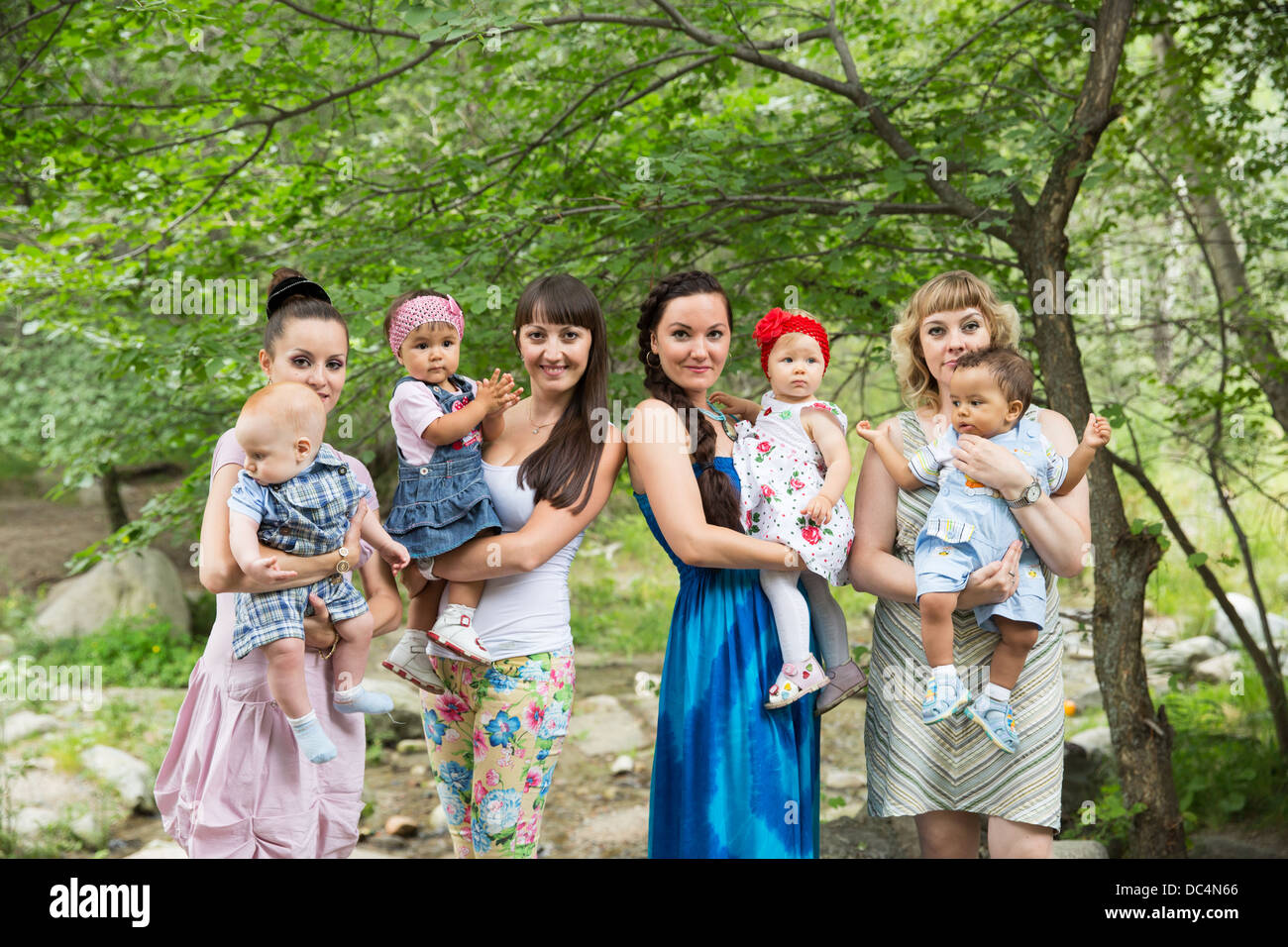 Four Happy Beautiful Mothers and children hugging and laughing. The ...
