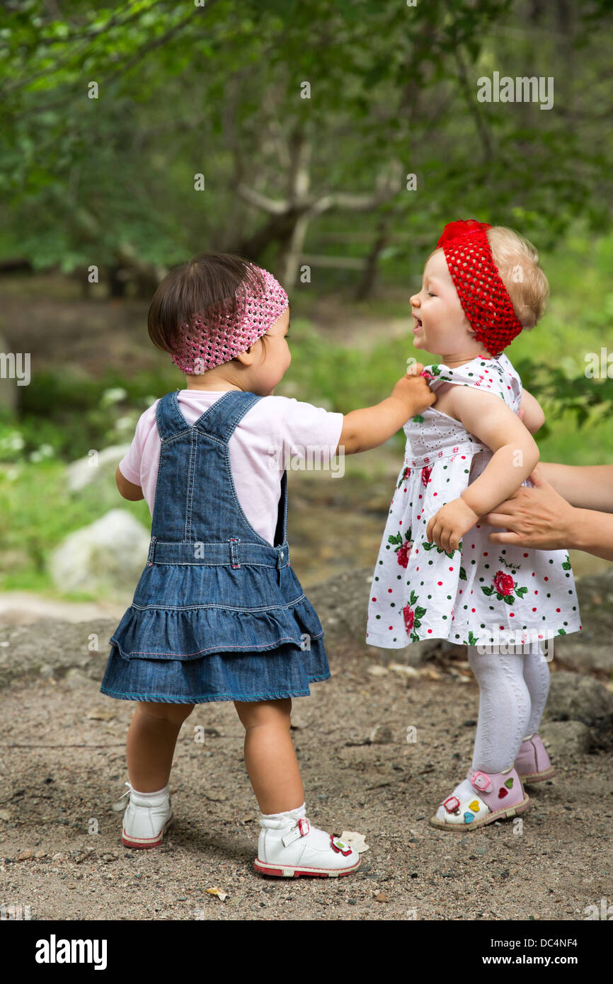 Two year-old adorable child girls playing on nature summer Stock Photo ...