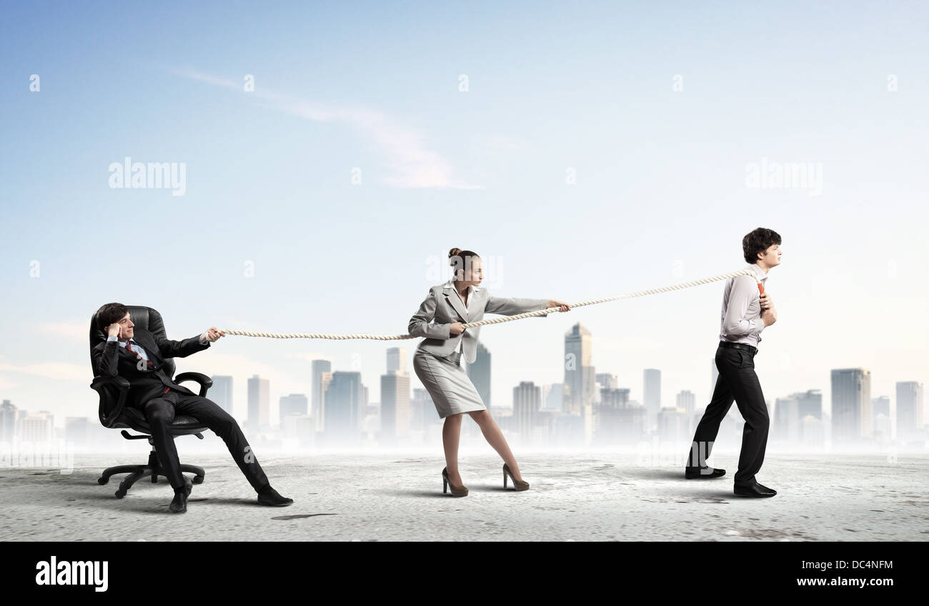 Three business people pulling rope Stock Photo - Alamy
