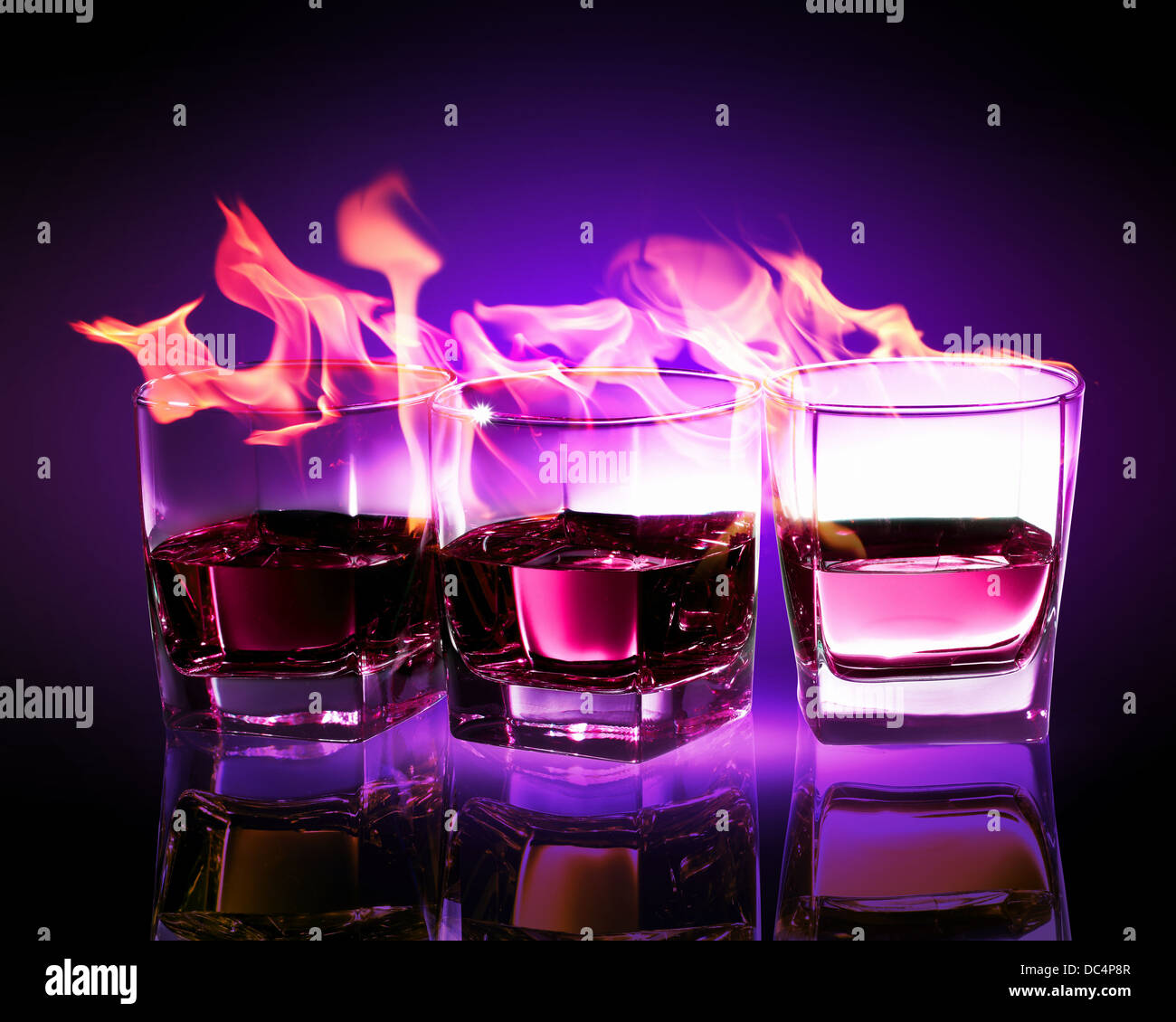 Three glasses of burning purple absinthe Stock Photo - Alamy