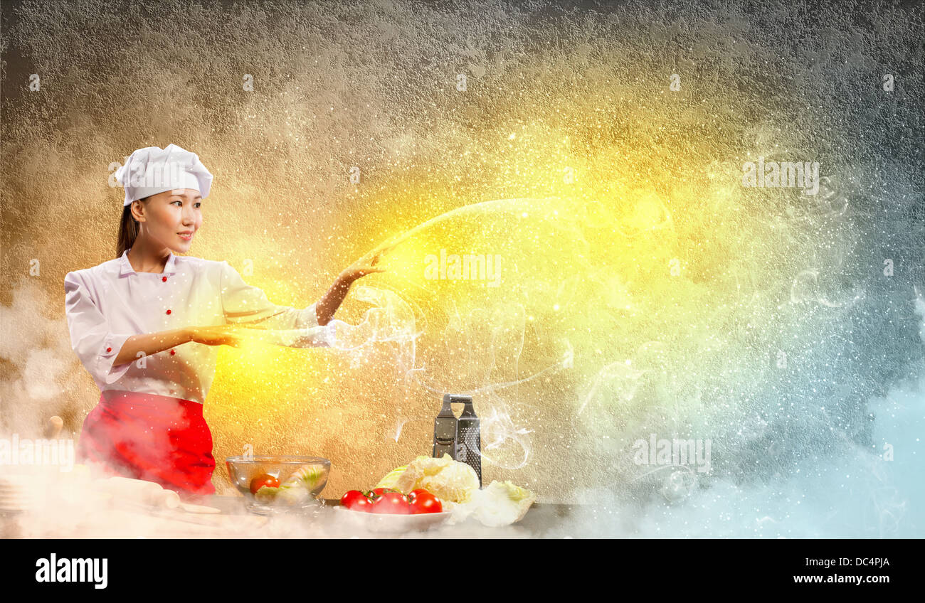 Asian female cooking with magic Stock Photo - Alamy