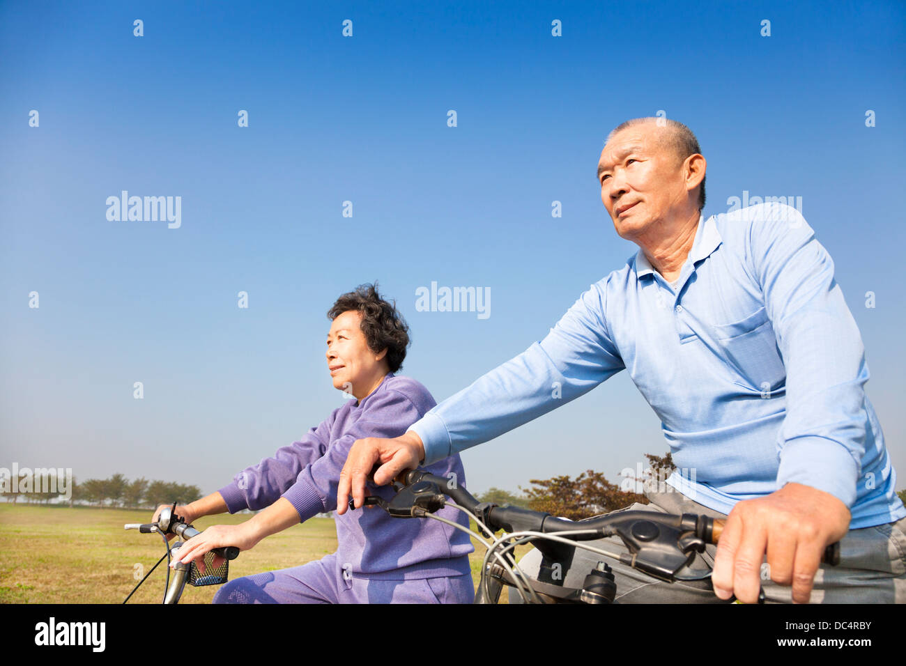 Happy elderly seniors couple biking Stock Photo - Alamy