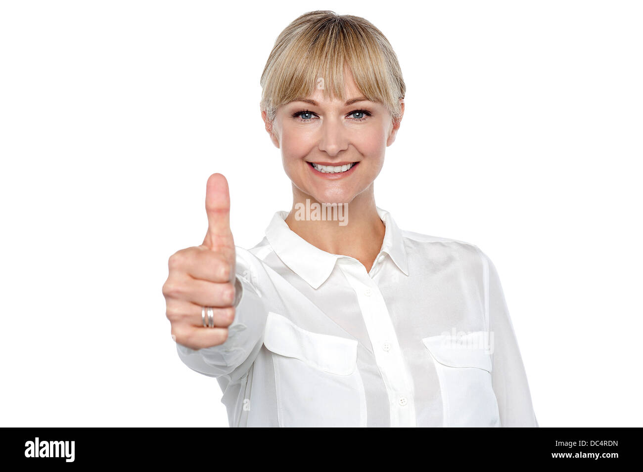 Blonde woman in formal attire showing thumbs up gesture Stock Photo - Alamy