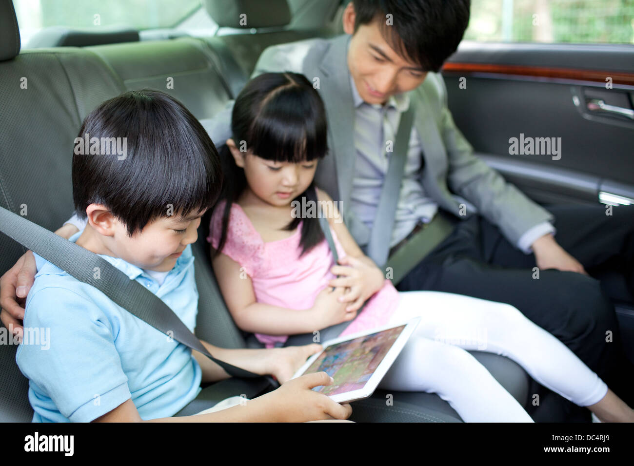 Happy family playing digital tablet in car Stock Photo - Alamy