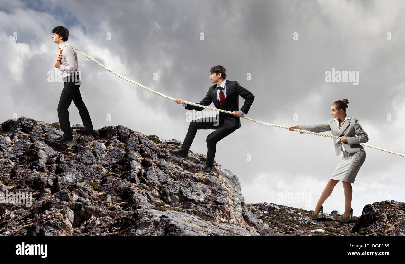 Three business people pulling rope Stock Photo - Alamy