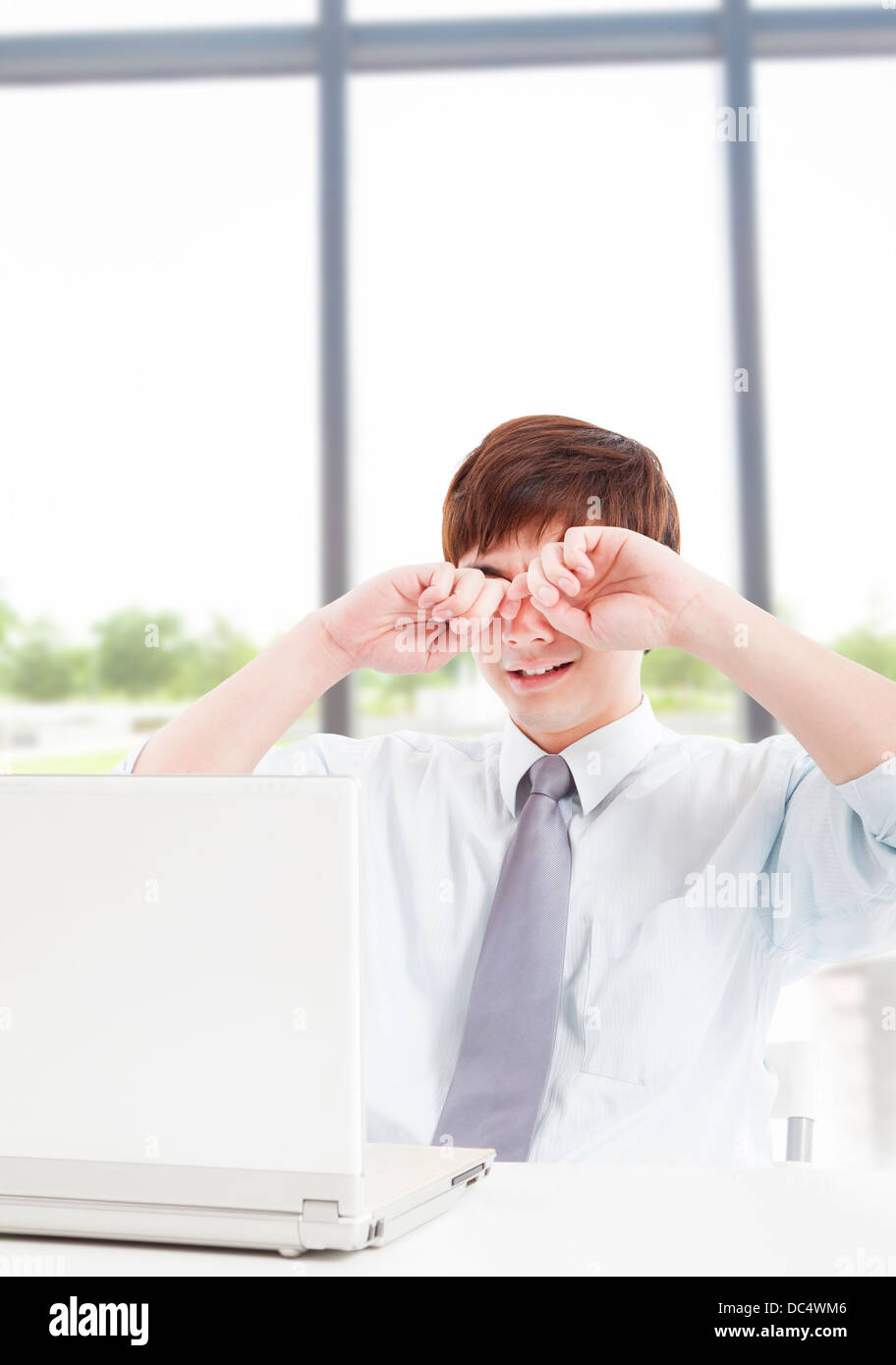 Young businessman with tired eyes and working in office Stock Photo - Alamy