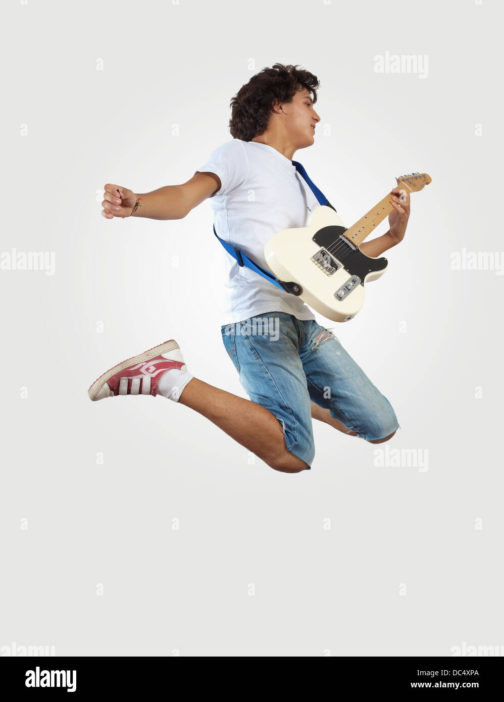 young man playing on electro guitar and jumping Stock Photo - Alamy