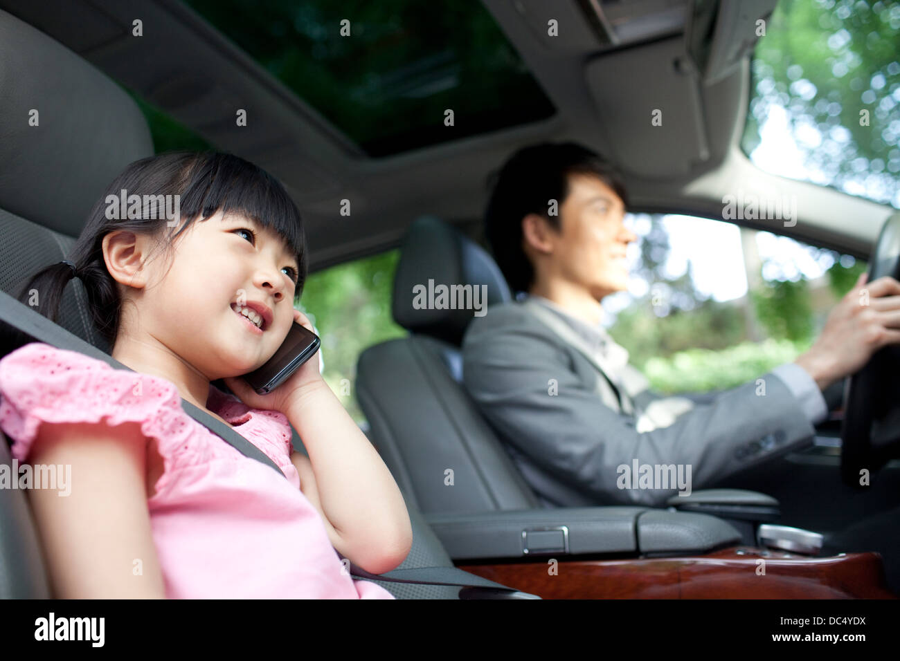 Cheerful father driving with daughter in front seat Stock Photo - Alamy