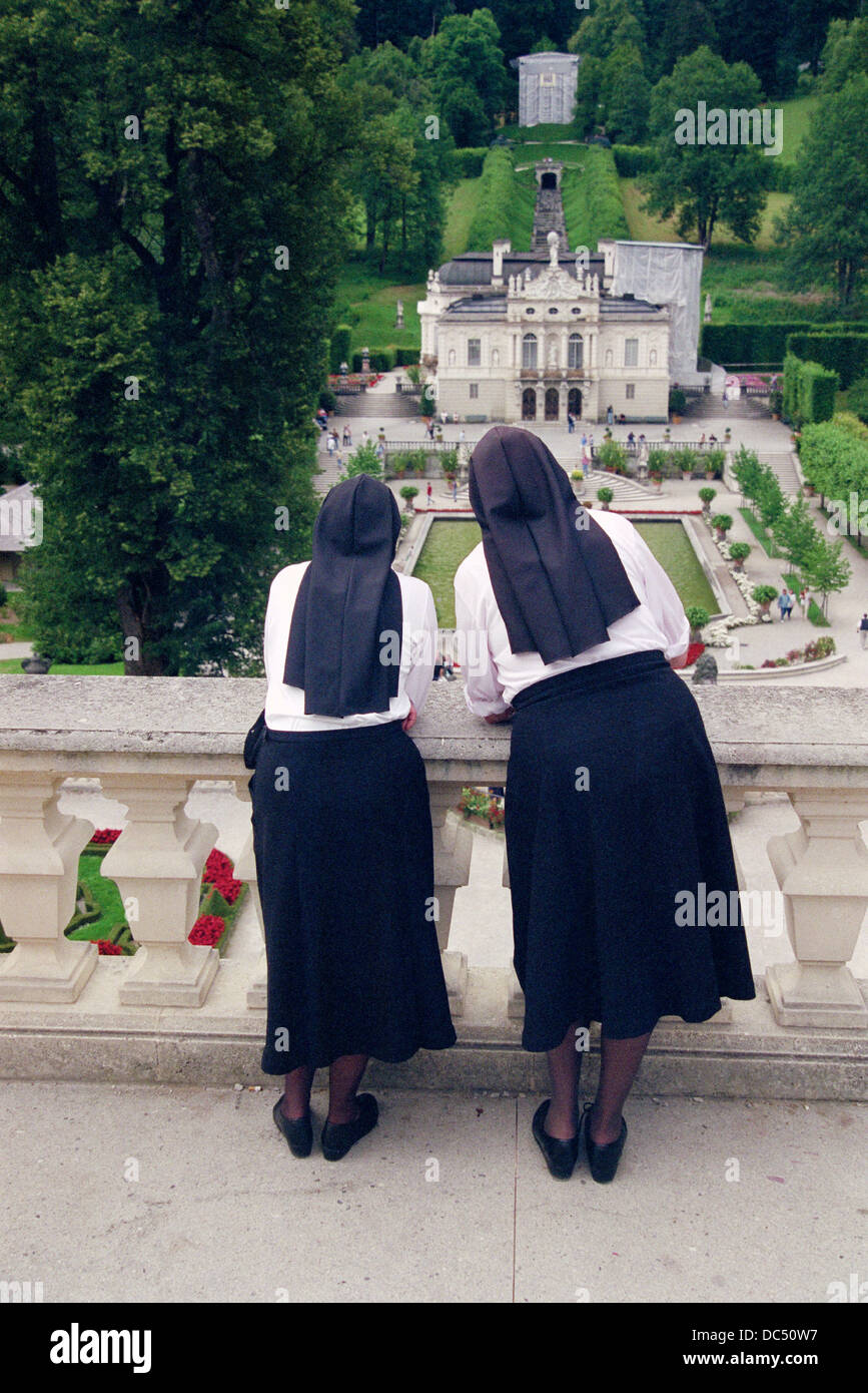 Two nuns rest on a railing overlook and take in the surroundings during ...