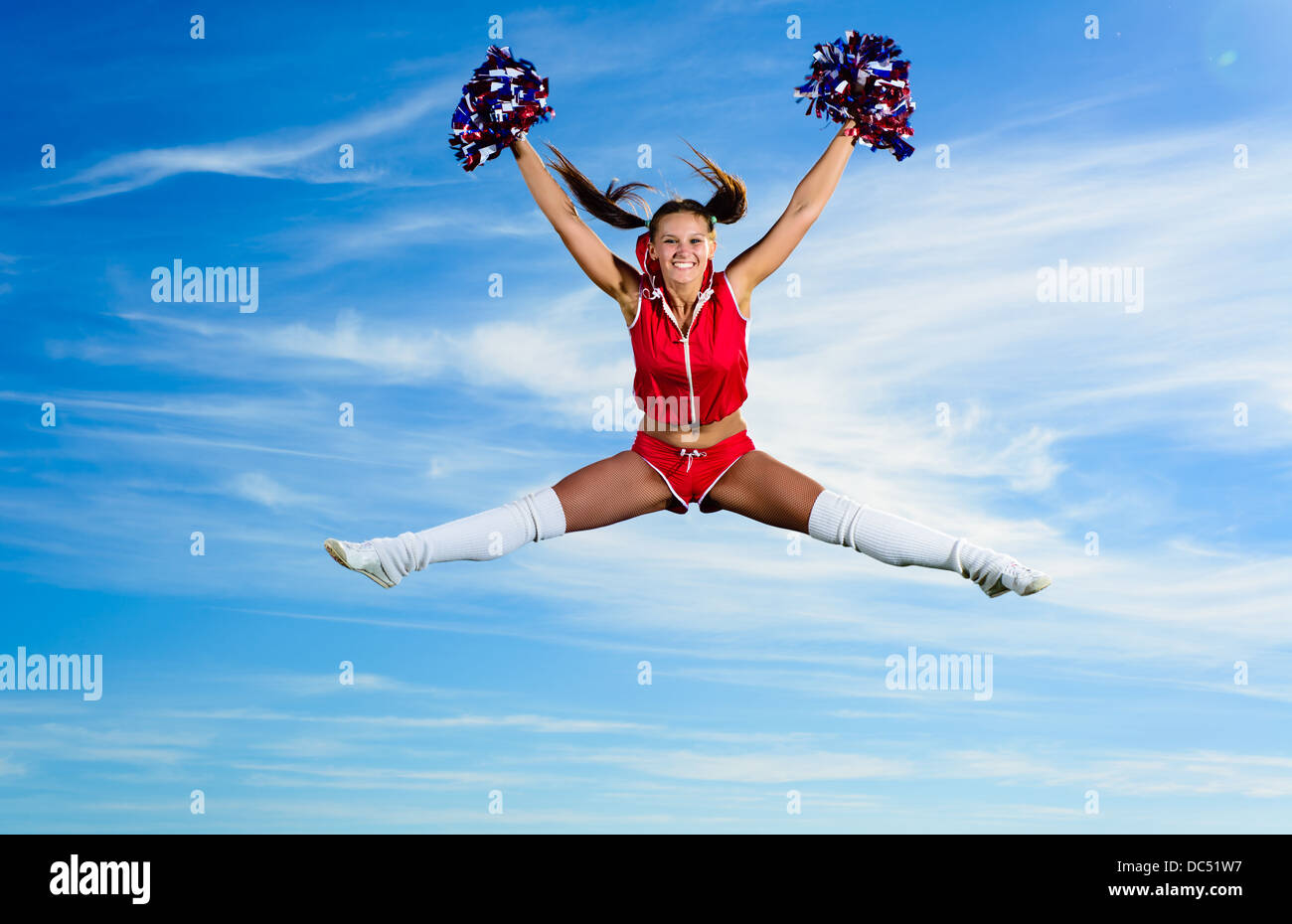 Young cheerleader in red costume jumping Stock Photo - Alamy