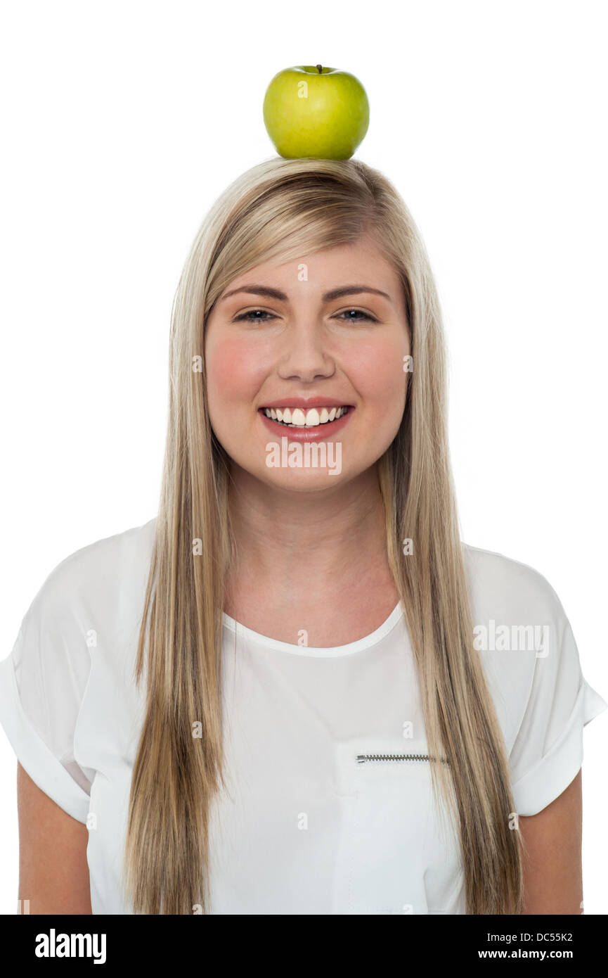 Smiling woman balancing an apple on her head Stock Photo - Alamy
