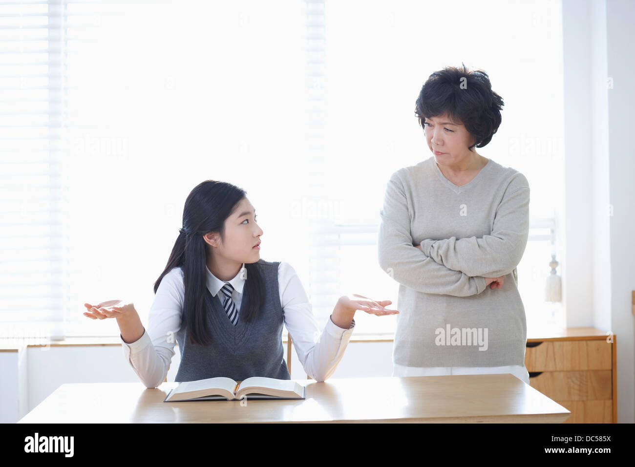 mother staring at daughter studying at desk Stock Photo - Alamy