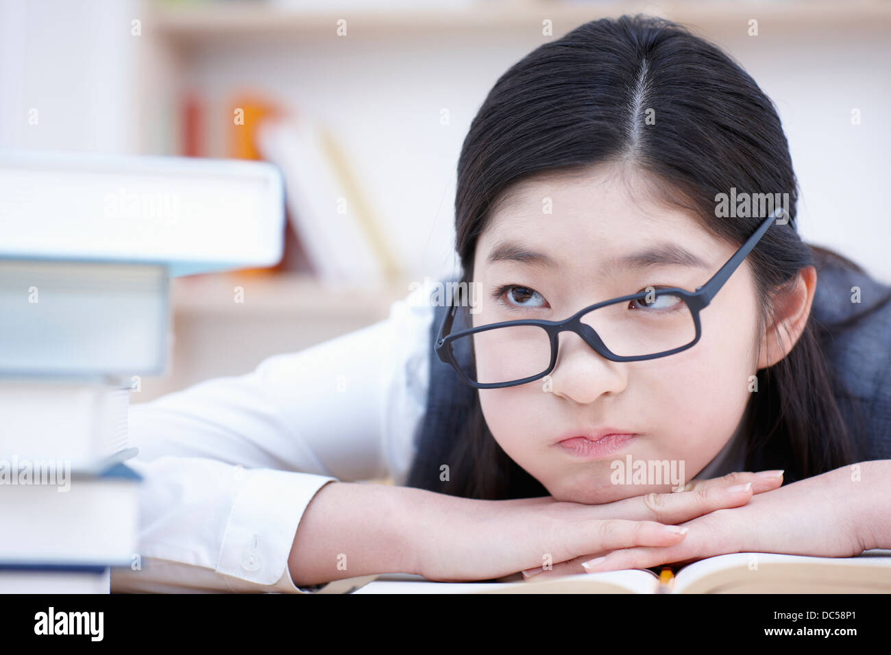 student in school uniform leaning her face on the desk Stock Photo - Alamy