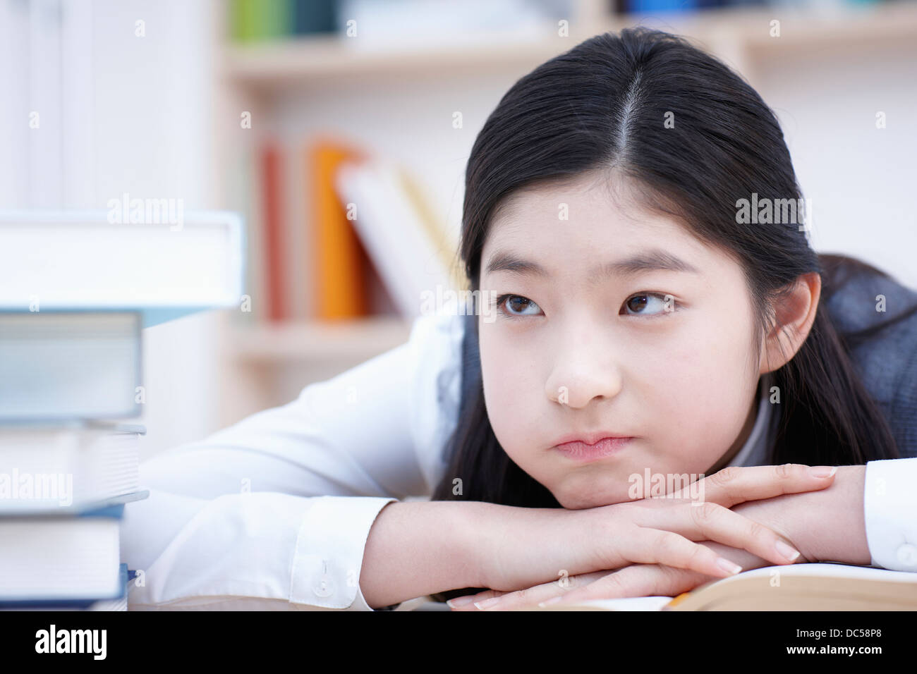 student in school uniform leaning her face on the desk Stock Photo - Alamy