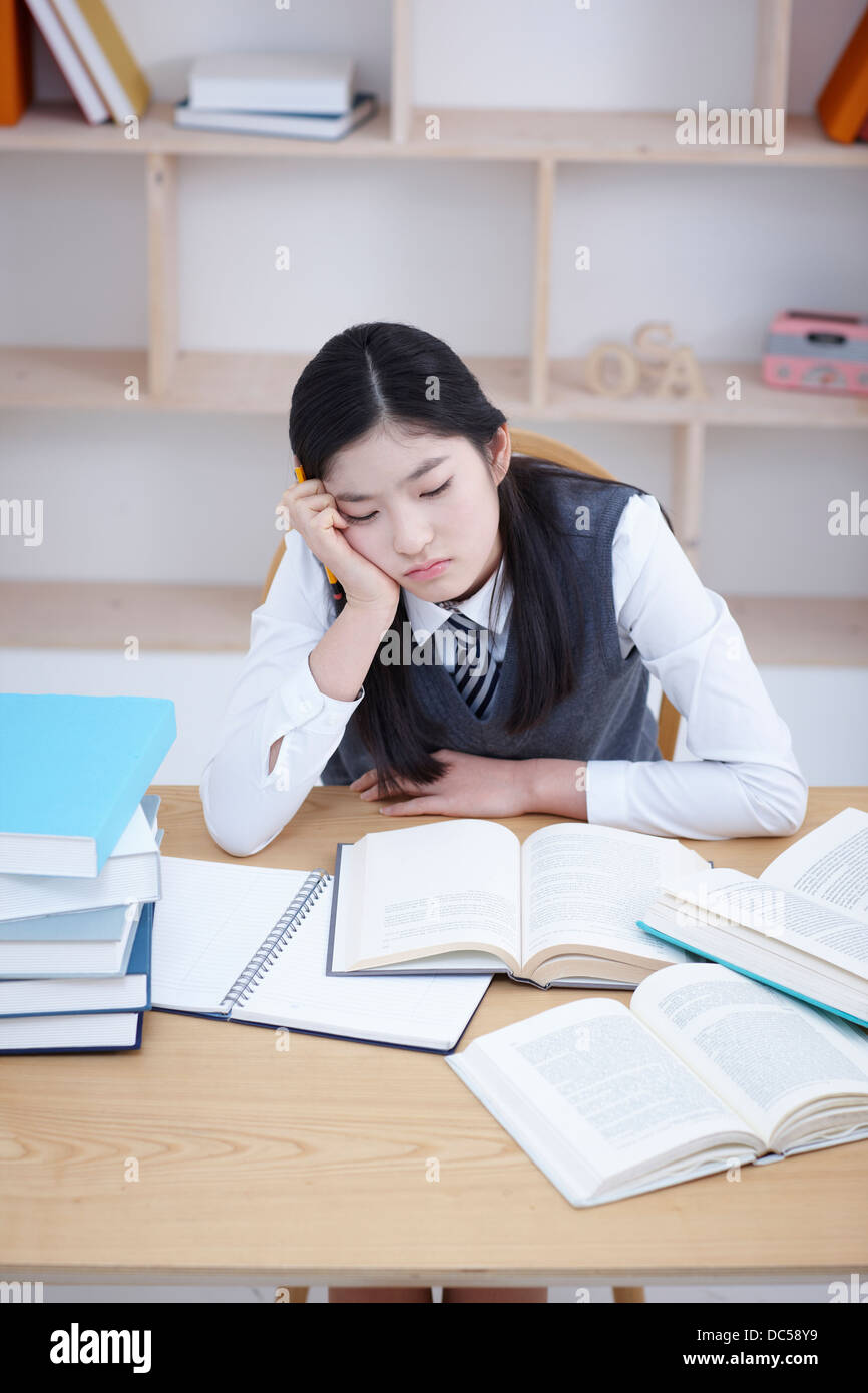 student in school uniform studying at desk looking dull Stock Photo - Alamy