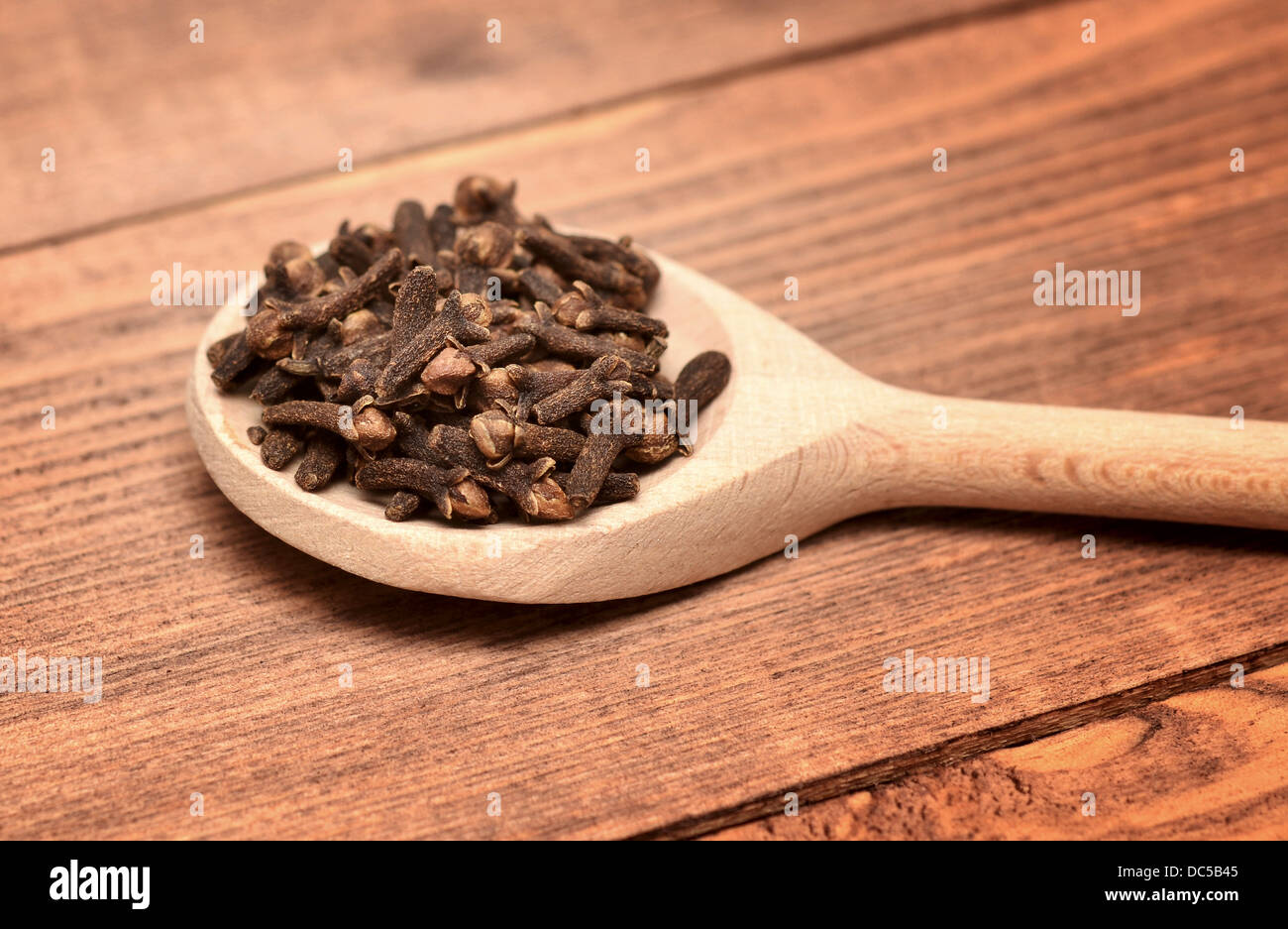 cloves in a wooden spoon on the table Stock Photo - Alamy