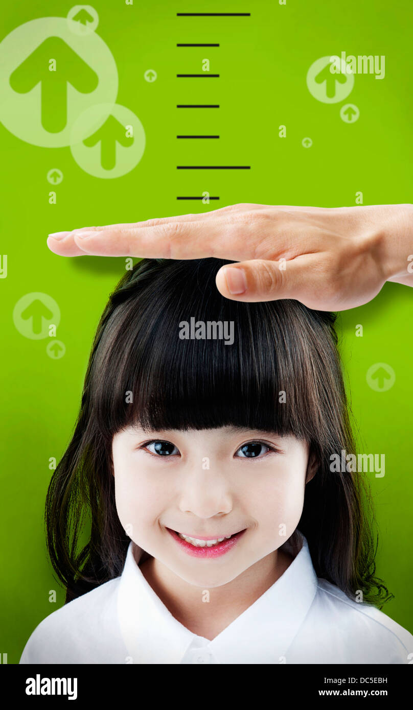 a girl in front of a green measuring board Stock Photo - Alamy