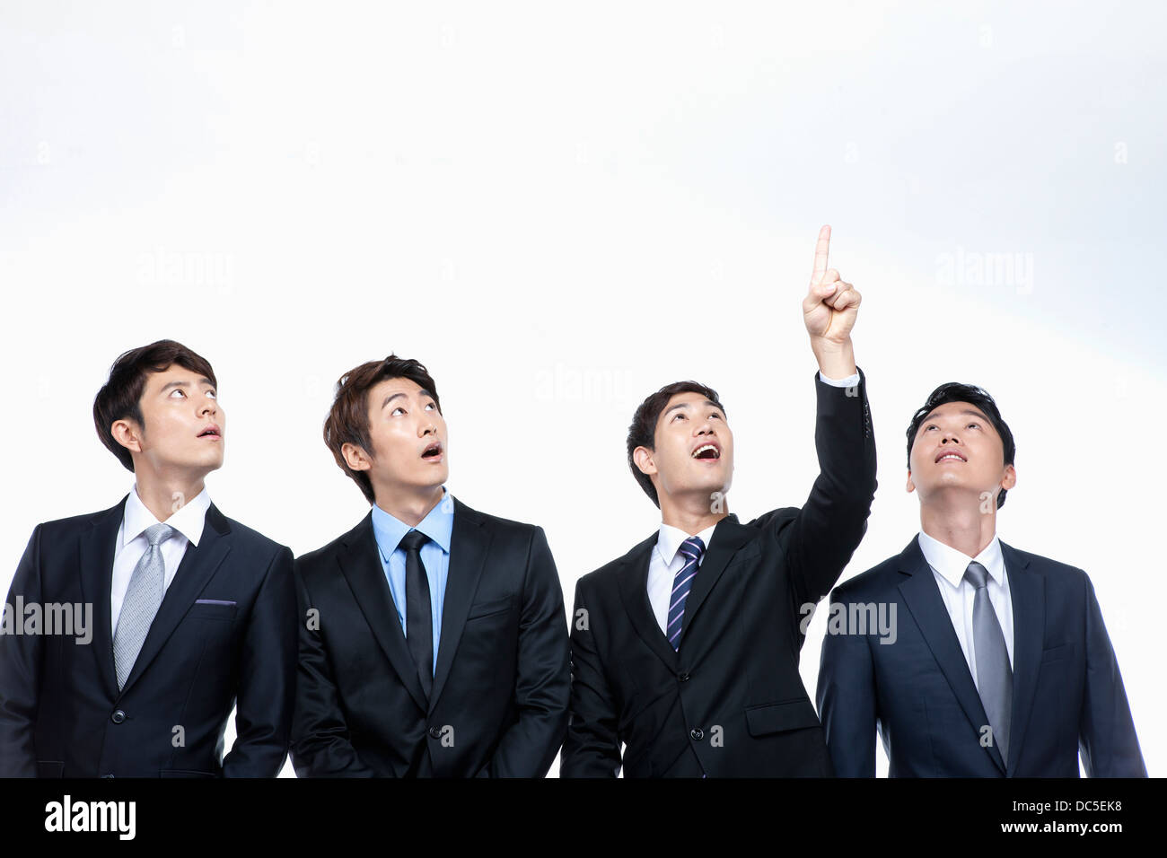 four businessmen looking up while standing in a line Stock Photo - Alamy