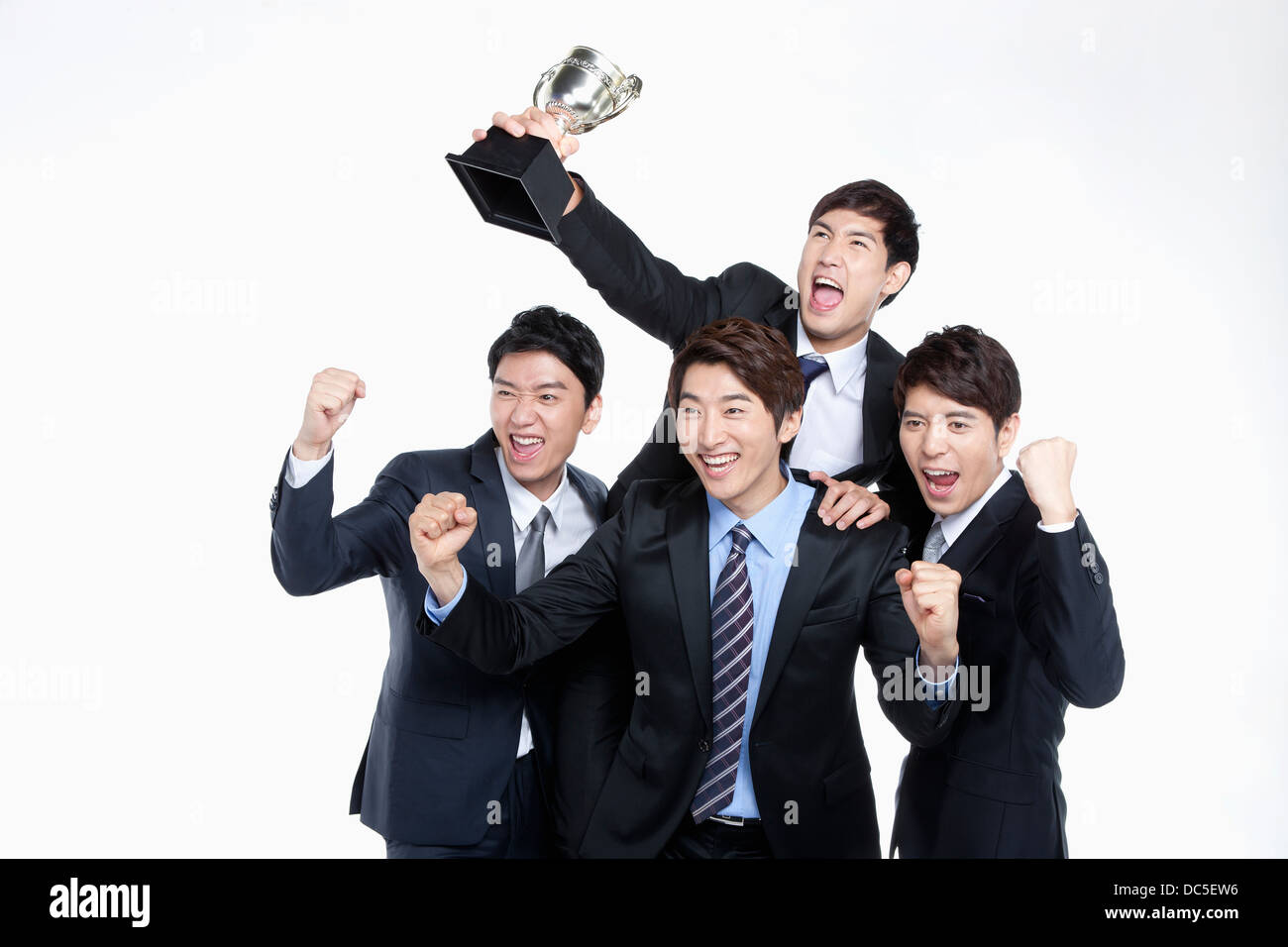 businessmen cheering with one holding trophy Stock Photo - Alamy