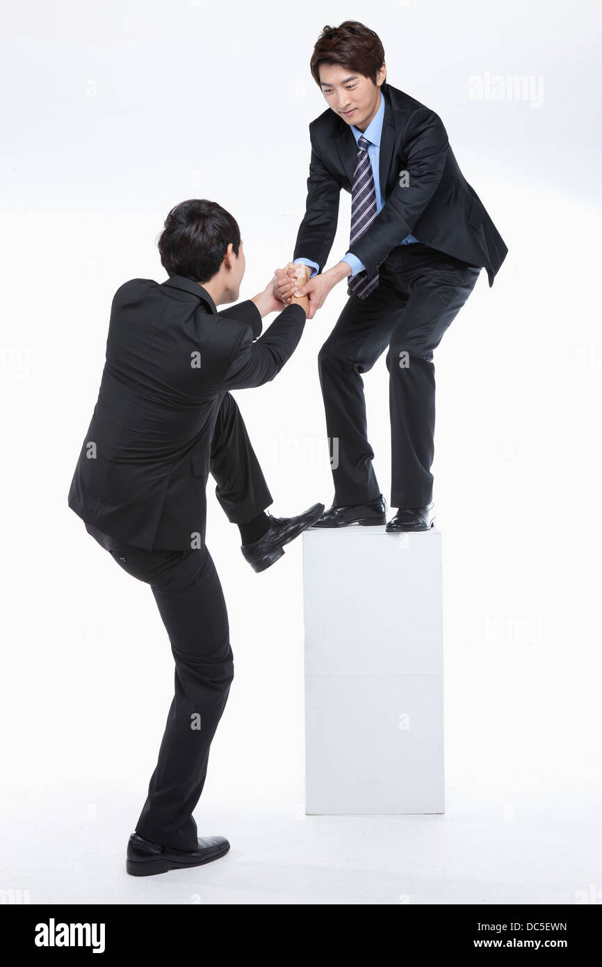 Businessman helping other man climb hi-res stock photography and images ...