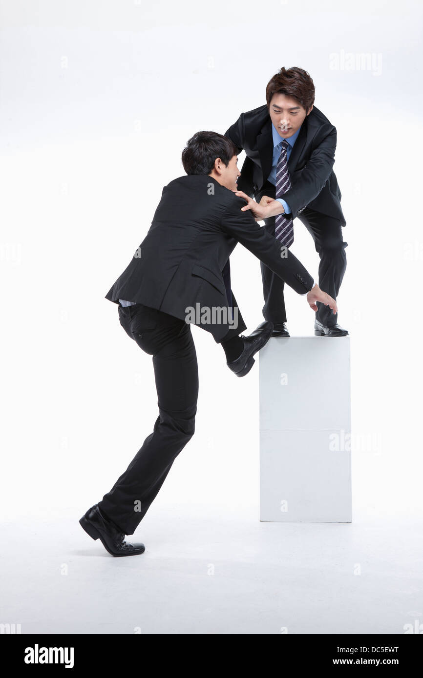 a businessman trying to push away a man from climbing up Stock Photo ...