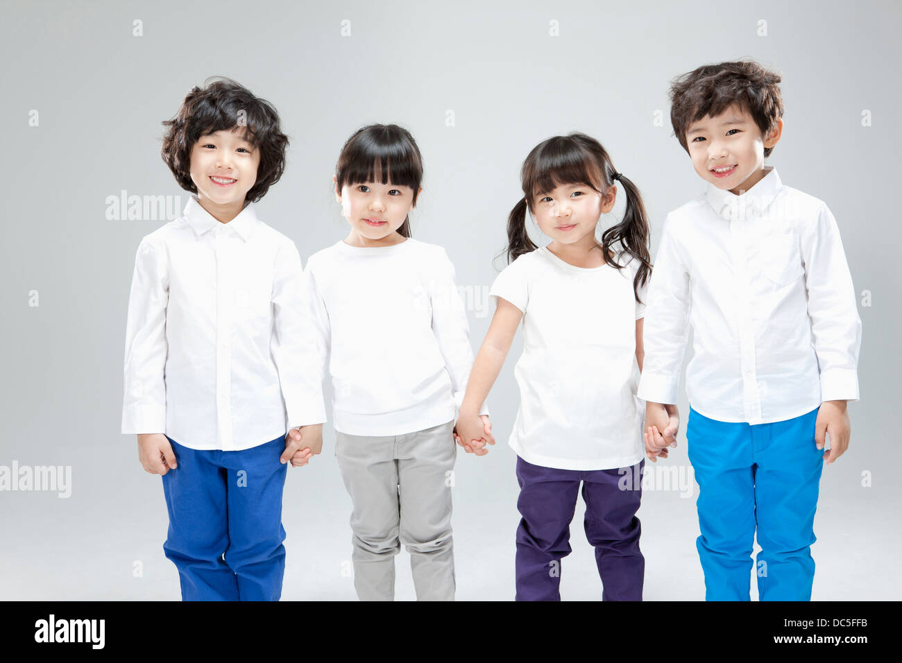 kids standing hand in hand in grey background Stock Photo - Alamy