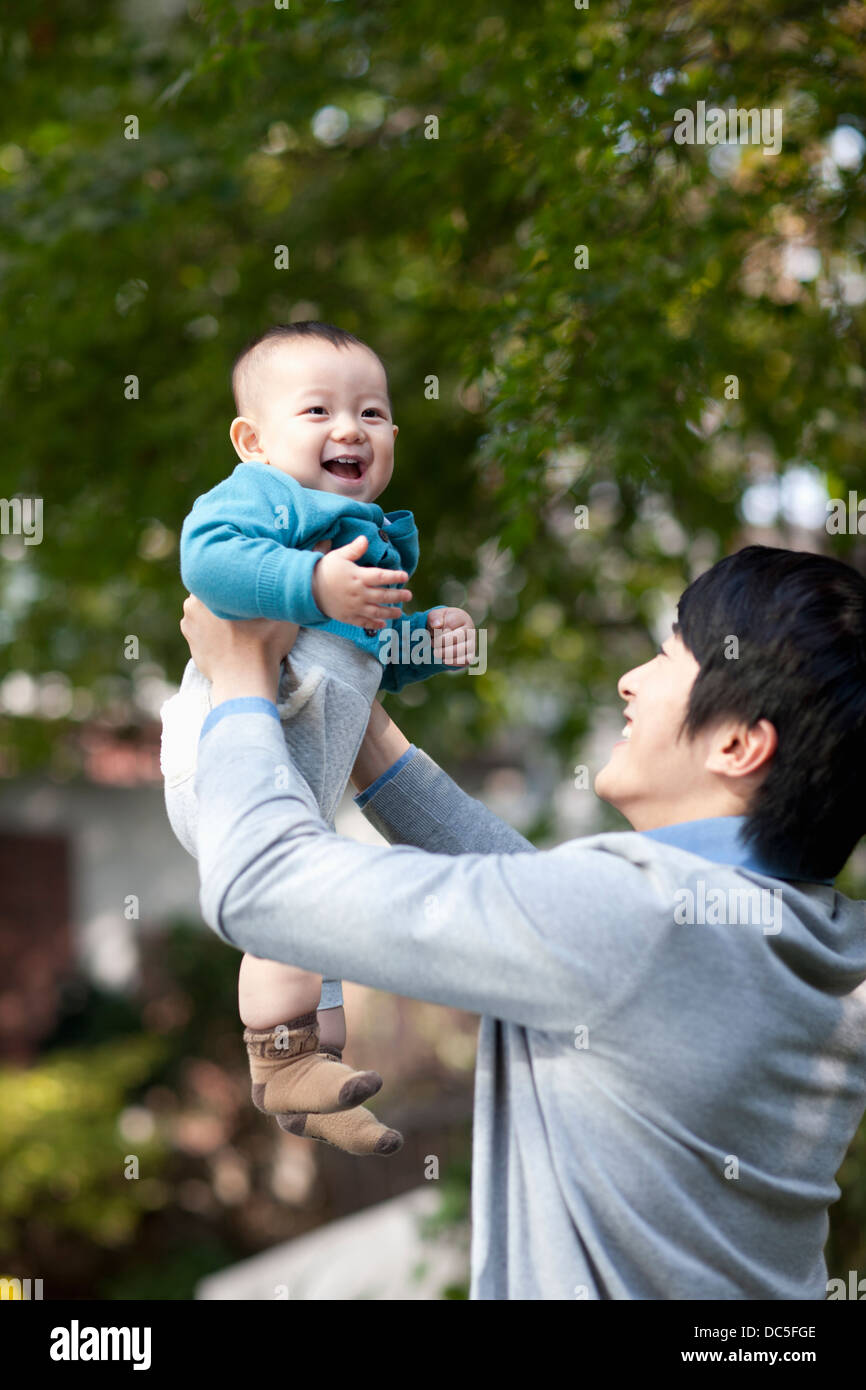 a father lifting a baby in the air Stock Photo - Alamy